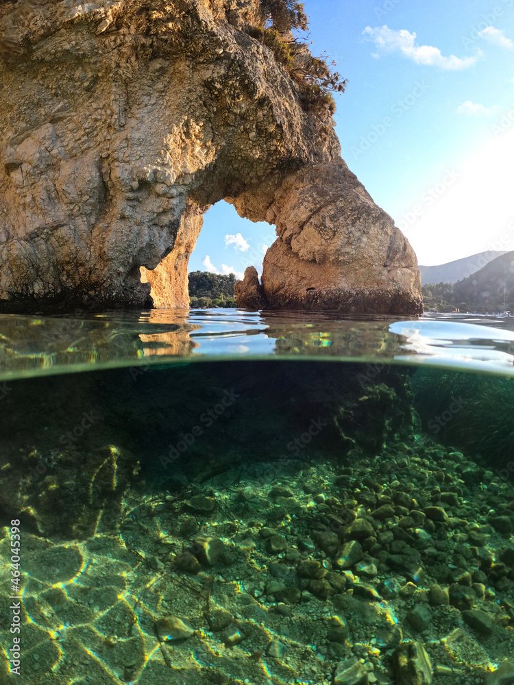Underwater split photo of small white rock cave with crystal clear ...