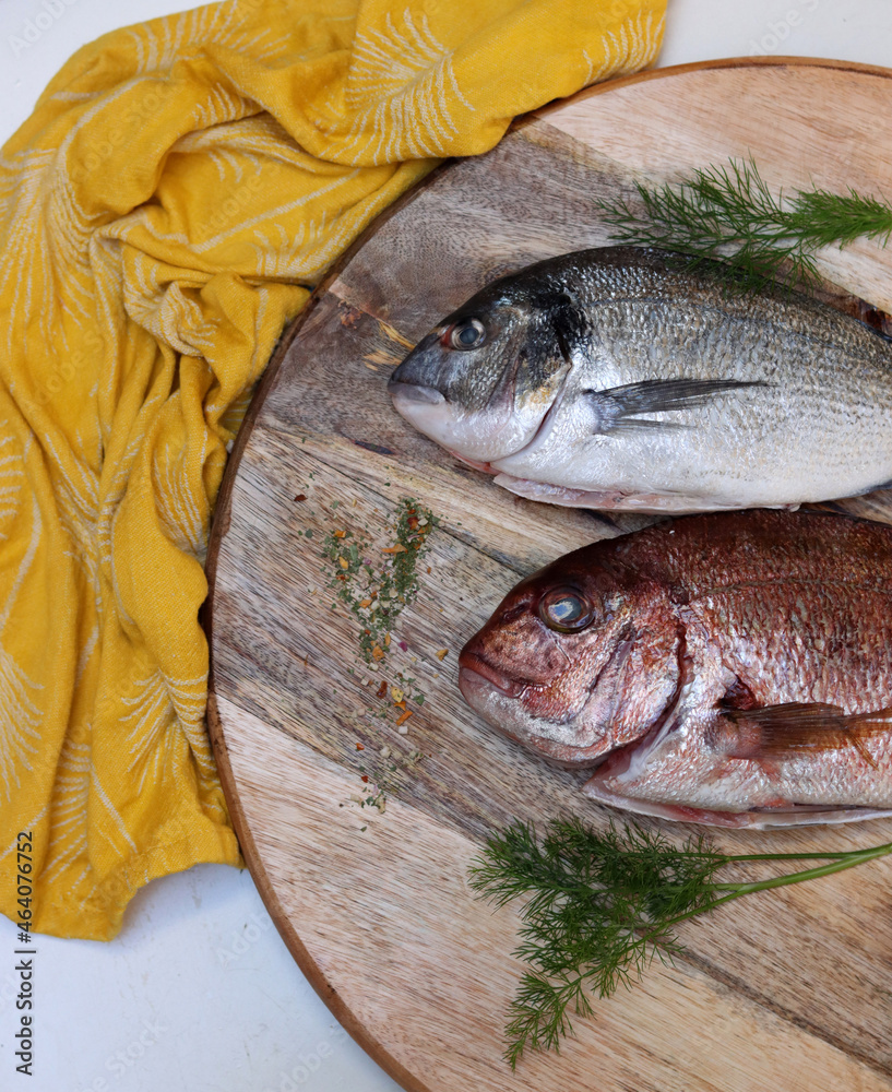 Raw Gilt-head Bream of two different types on a table. Fresh fish on ...