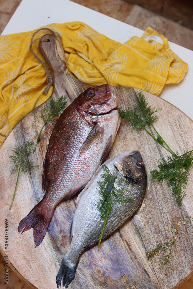 Raw Gilt-head Bream of two different types on a table. Fresh fish on ...