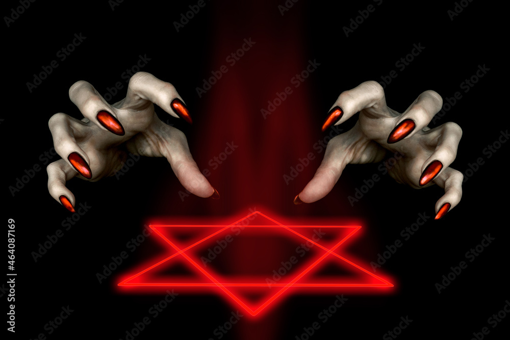 Black magic ritual. Scary witches hands with red long nails and a ...