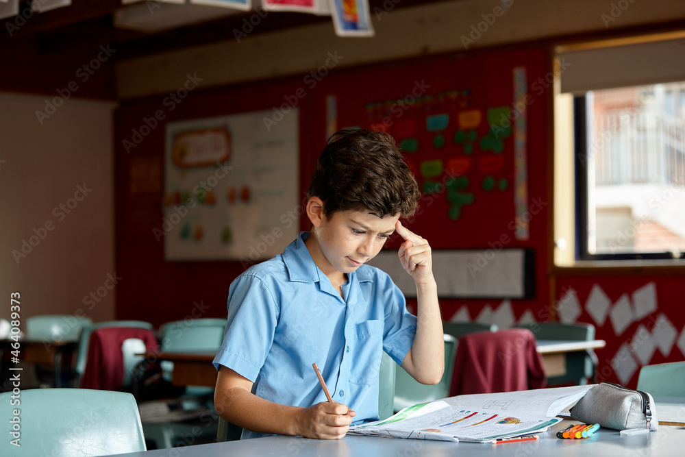 Primary school student in classroom working on homework Stock Photo ...