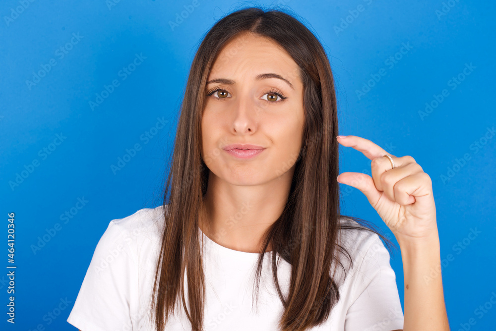 Displeased young european girl wearing white t-shirt on white ...
