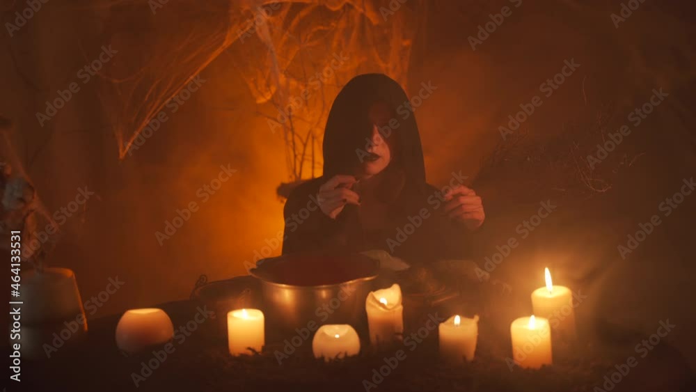 Witch house. Scary witch in hood does voodoo black magic ritual on the ...