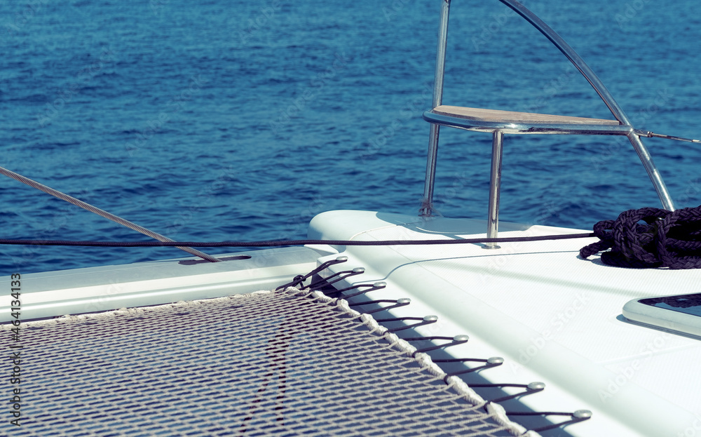 Catamaran front deck, net of artificial fibres on water background ...