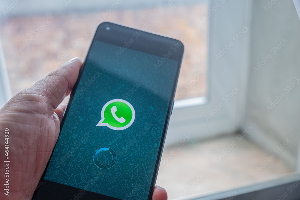 Hand holding mobile phone with WhatsApp logo on the screen Stock Photo ...