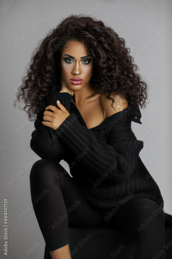 A 3/4 portrait of a confident young Latin woman with long bouncy curly ...