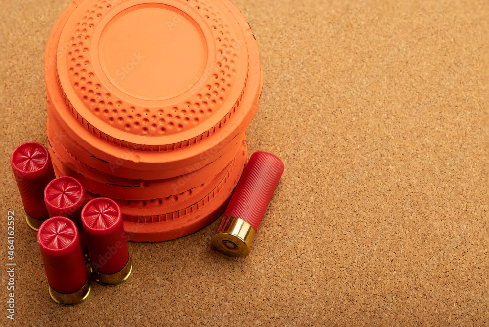 Clay disc flying targets and shotgun bullets on cork background ,Clay ...