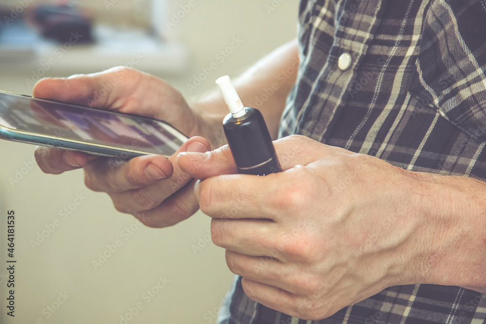 Electronic cigarette and mobile telephone in the hands of a smoker. Age ...
