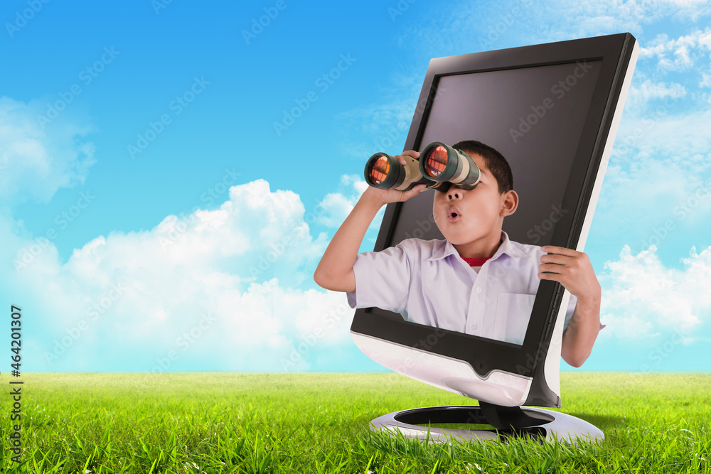 Boy looking through binoculars from a computer monitor with the sky in ...