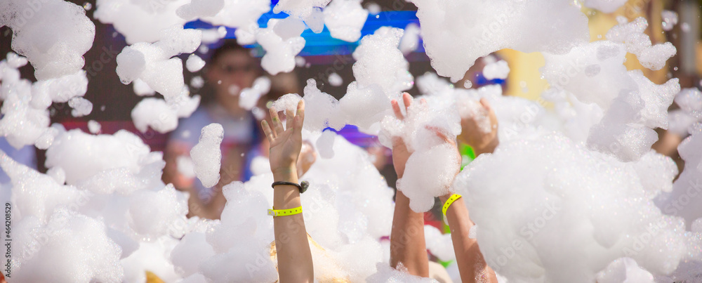 Foam party entertainment, people have fun raising hands catch soap ...