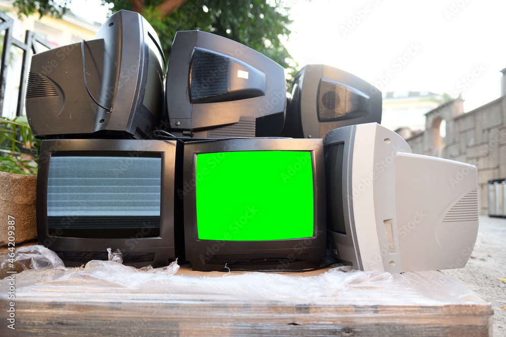 Dump trash can of old CRT TVs with green screens for adding video and ...