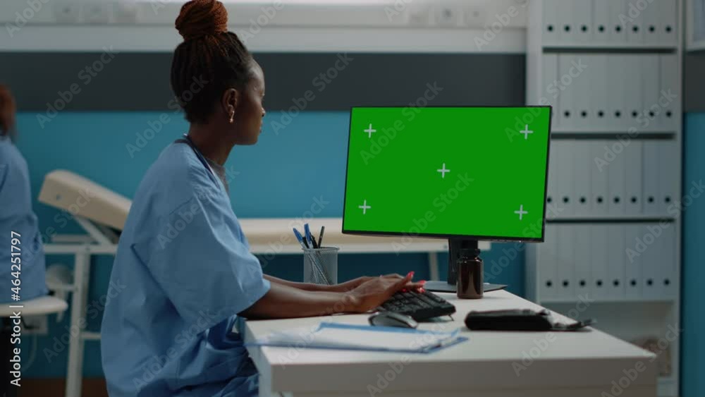 Nurse working with keyboard and horizontal green screen on computer at ...