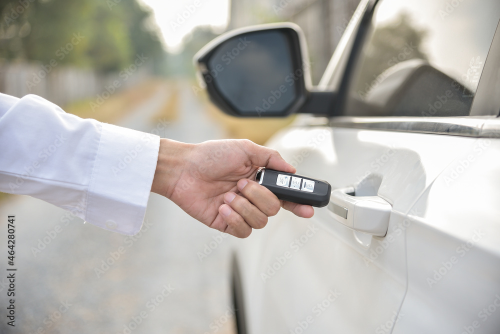 Car remote control by smart key, Hand holding smart key to lock doors ...