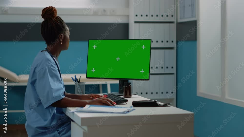 Medical assistant using horizontal green screen on computer in cabinet ...