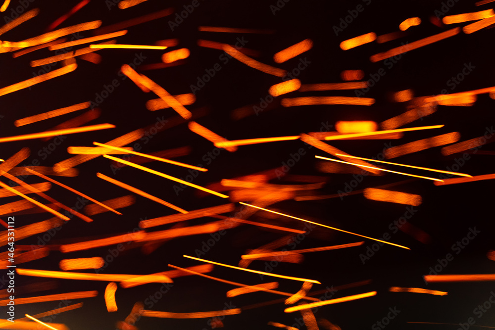 Burning embers glowing flying away particles over black background ...