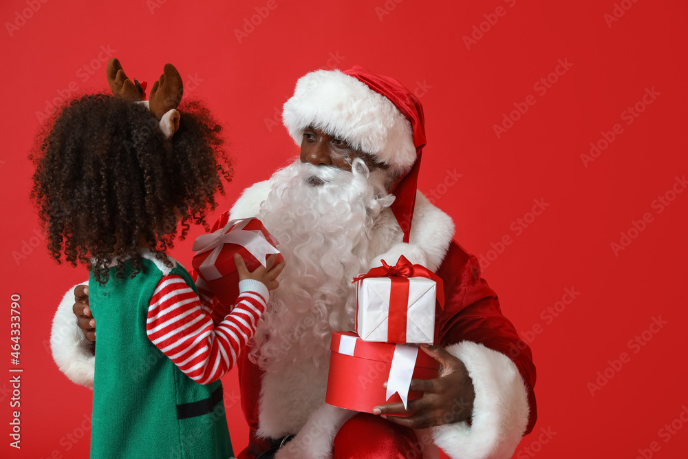 Cute little elf with Santa Claus and gifts on red background Stock ...
