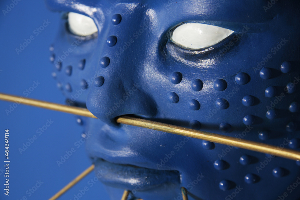 Detail of the face of the aboriginal statue. Androgynous features, blue ...