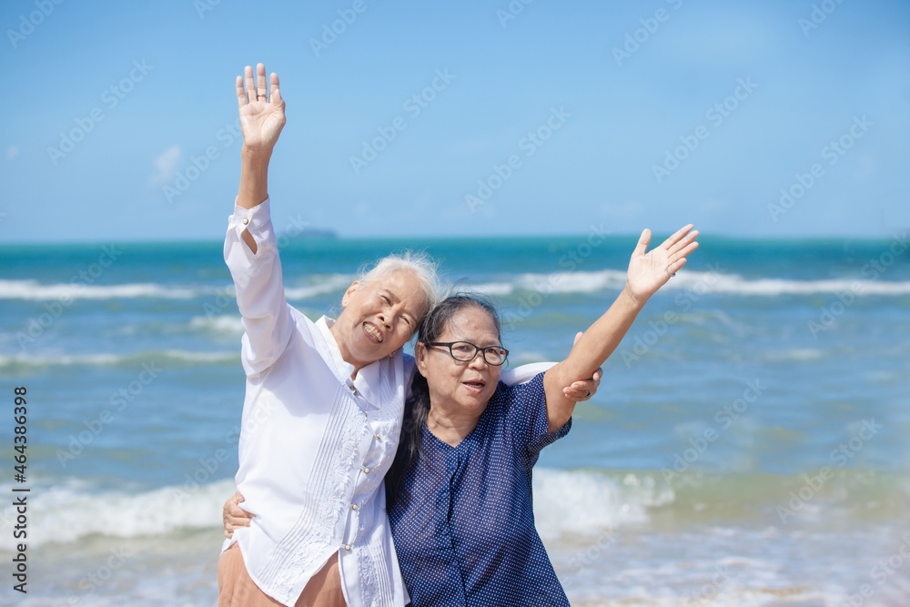 woman Asian senior elder walking together on the beach. Happy senior ...