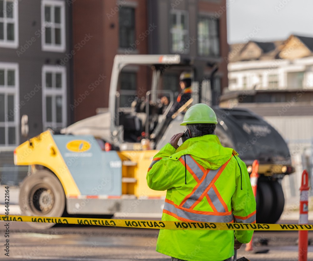 Roadworks signal with worker standing. Traffic control manager watching ...