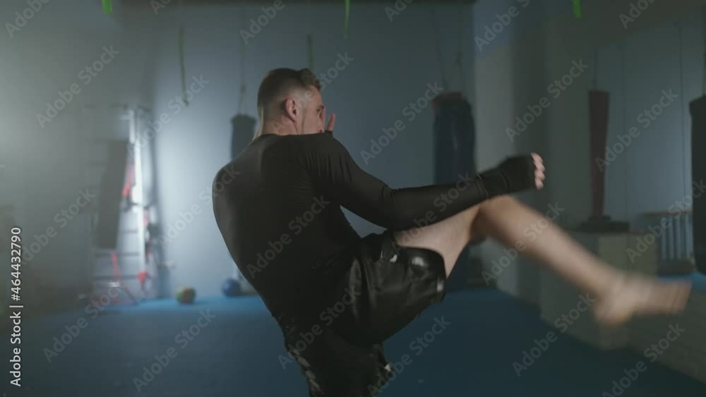 Fighter trains his punches and defense in the boxing gym, a man boxer ...
