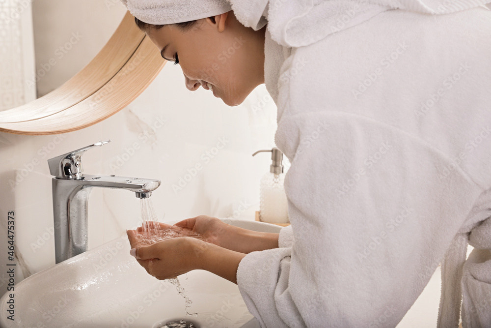 Beautiful teenage girl washing face with cleansing foam in bathroom ...