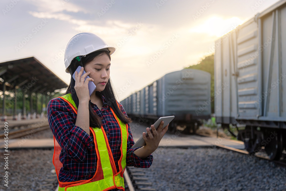 Women engineer railway wearing safety uniform holding tablet and ...