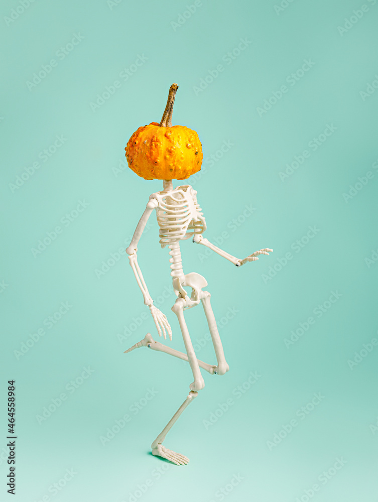 Human skeleton with orange pumpkin head dancing and waling against ...