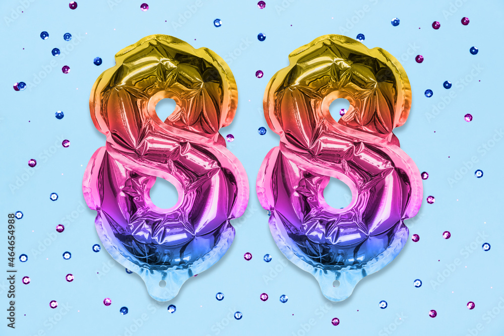 Rainbow foil balloon number, digit eighty eight on a blue background ...