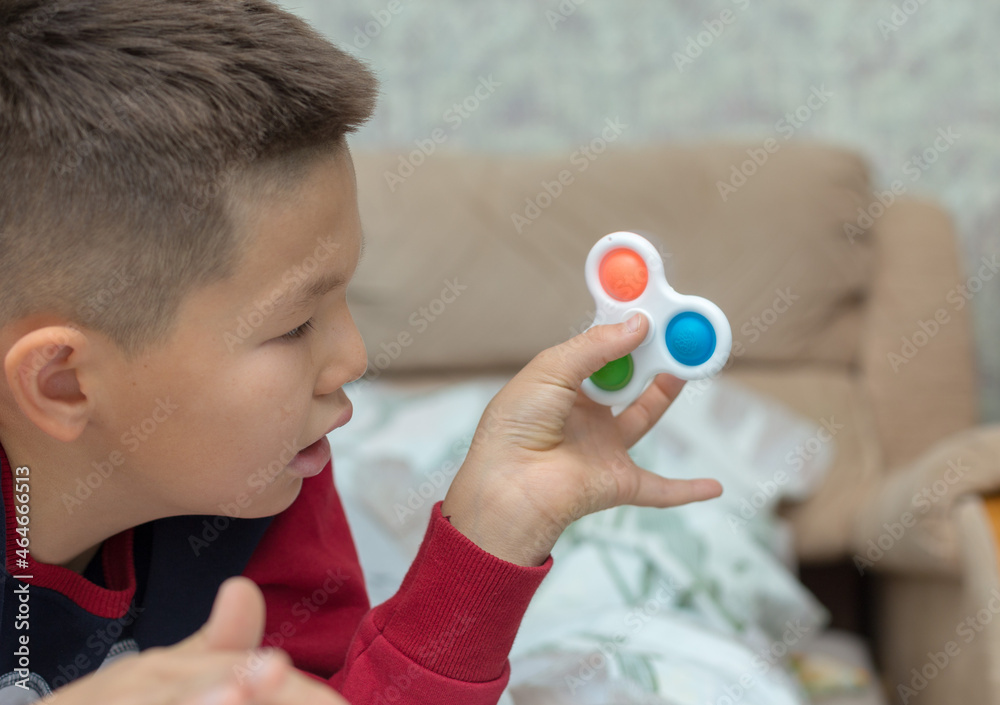 Portrait of a child with a modern popit toy. Colorful and bright pop ...