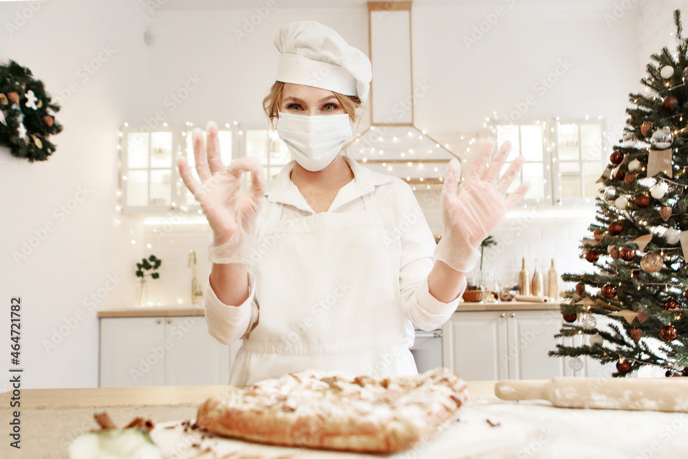 a cheerful chef prepares a Christmas cake. Lady cook in a cute apron ...