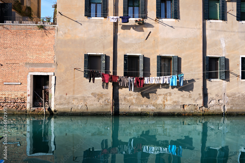 Washing lines along canal in Venice, Italy with reflection in water ...