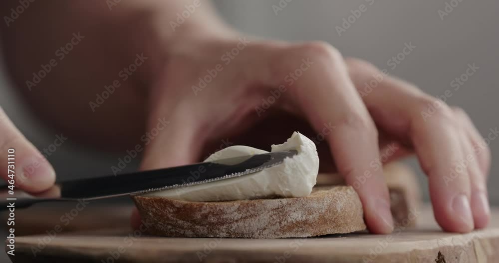 Slow motion man hand spreading cream cheese on dark ciabatta Stock ...
