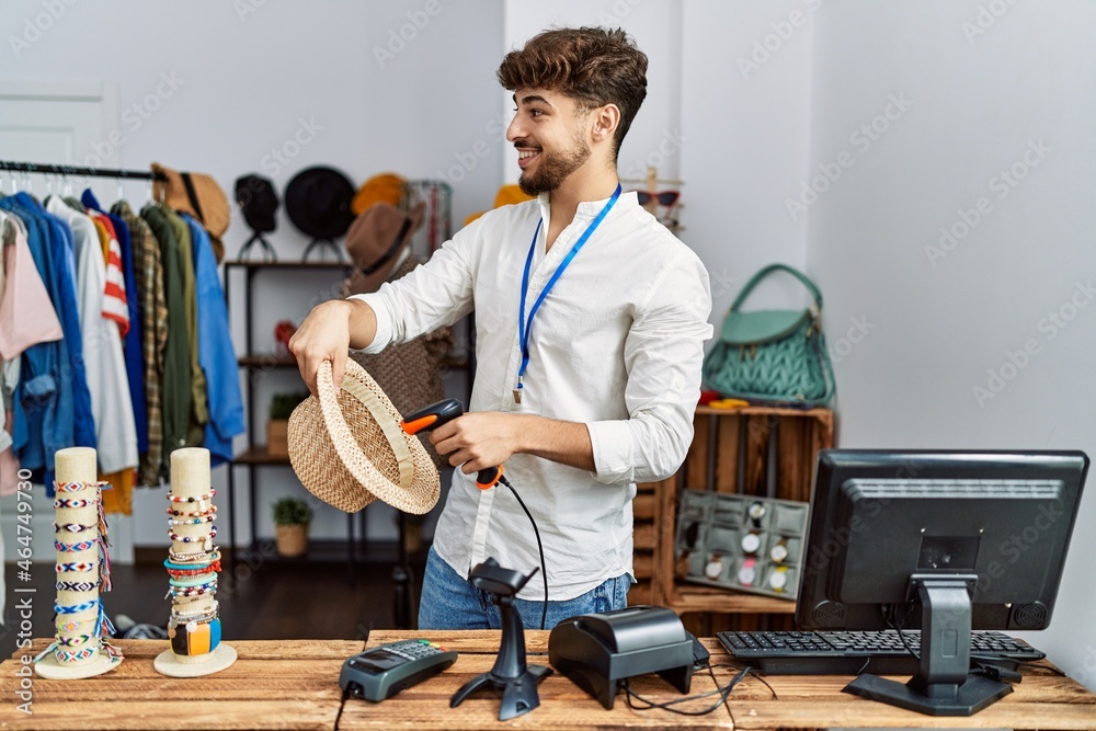 Young arab man smiling confident scanning hat using barcode reader at ...