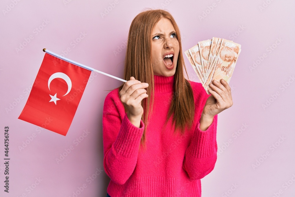 Foto de Young irish woman holding turkey flag and liras banknotes angry ...