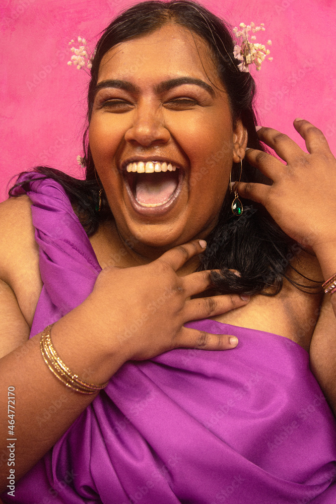 Malaysian Indian individual posed against pink background, styled in ...