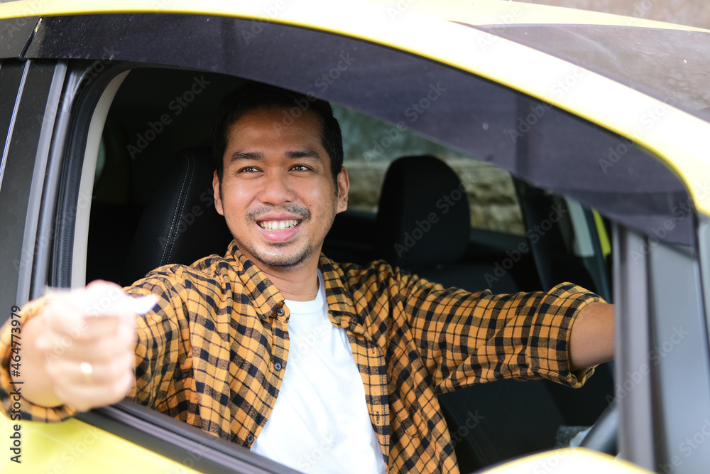 Adult Asian man smiling friendly while giving his car parking ticket ...