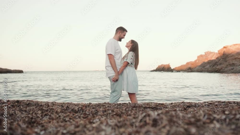 Young Romantic Couple Standing At The Beach And Facing Each Other With ...