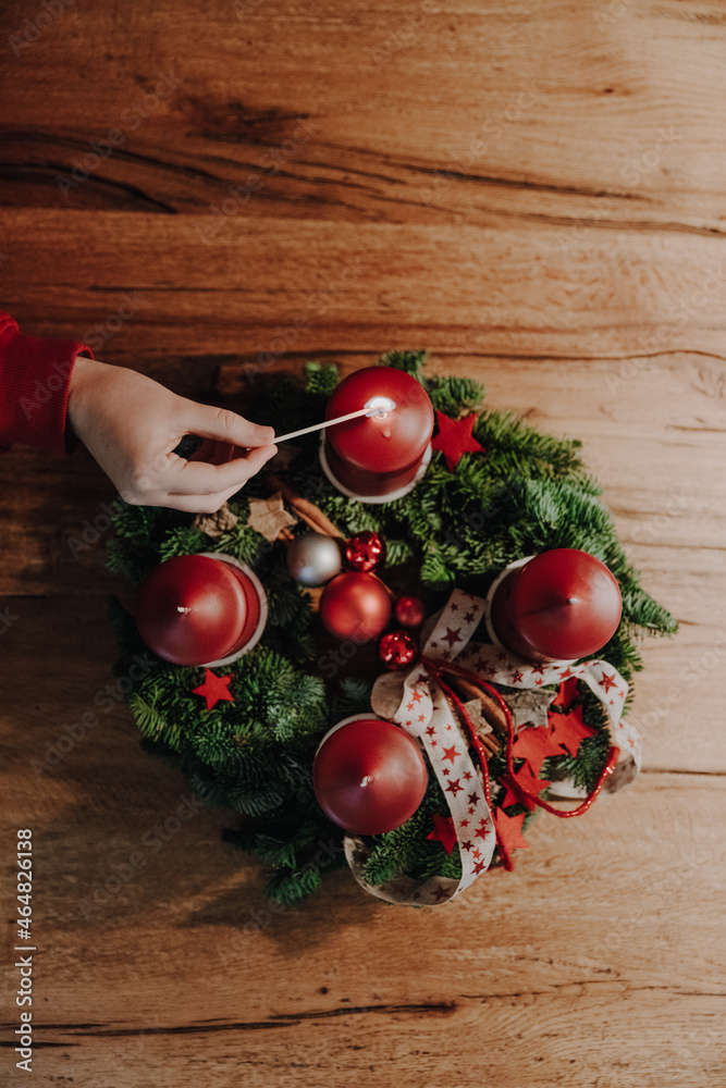 Child hand lighting the first candle of Advent Wreath on the first ...