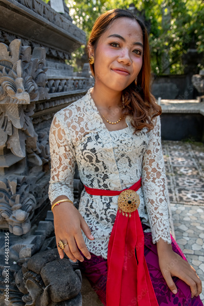 Young Local Girl at posing with a traditional gold sarong in front of a ...