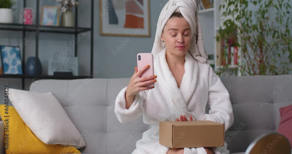 Close up of woman vlogger wearing white bathrobe, towel wrapped around ...