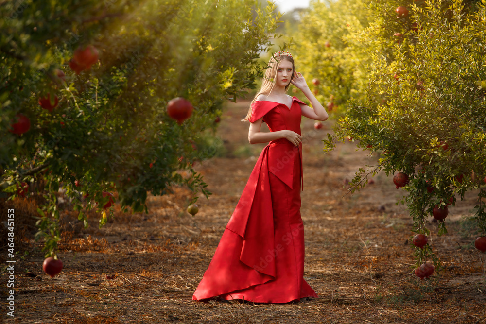 Beautiful young girl in long red dress in a pomegranate garden. Jewish ...
