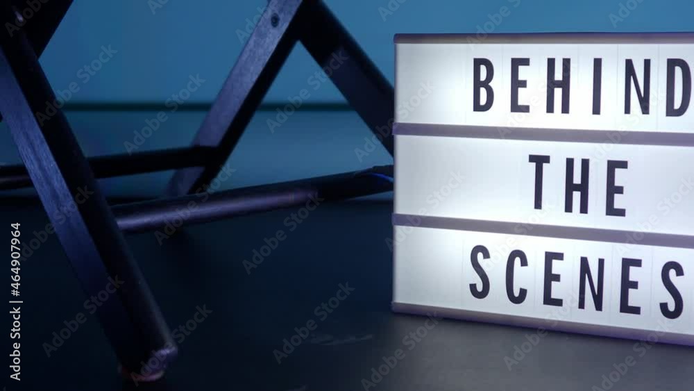 Behind the scene light box. Black text on white lightbox of word Behind ...