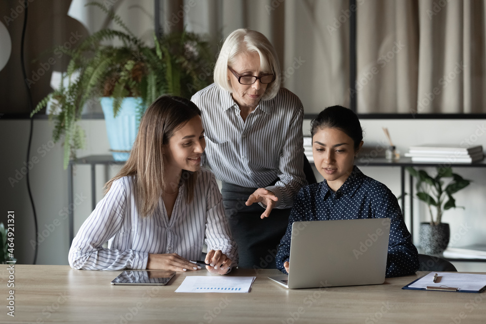 Group of two multiethnic females students sit at desk on workshop ...