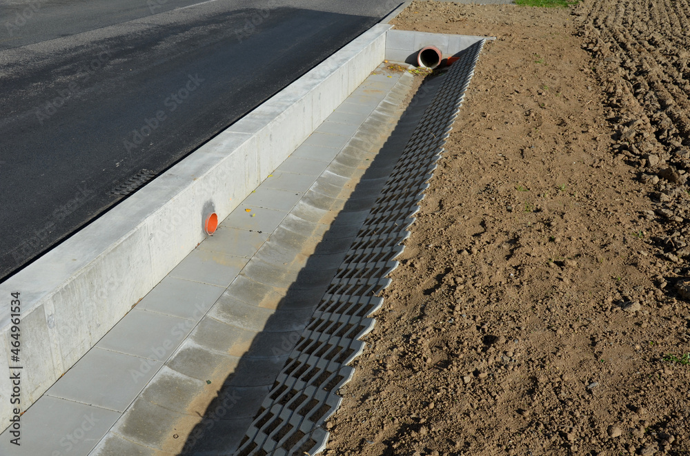 on the side of the road there is a concrete wall support and a ditch ...