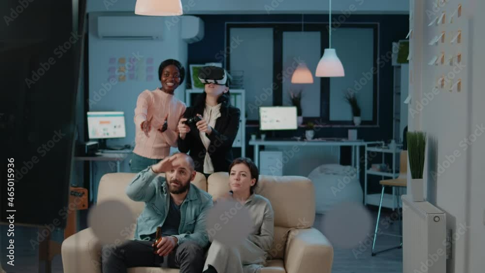 Multi ethnic group of workers playing video games to celebrate party ...