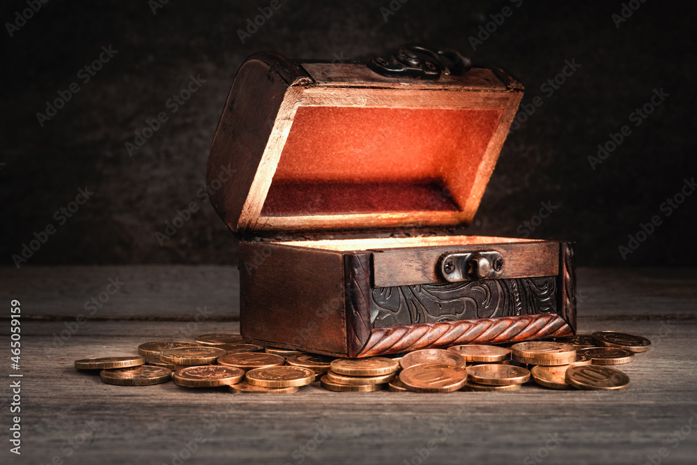 old wooden chest with coins on the table, chest open, bright light ...