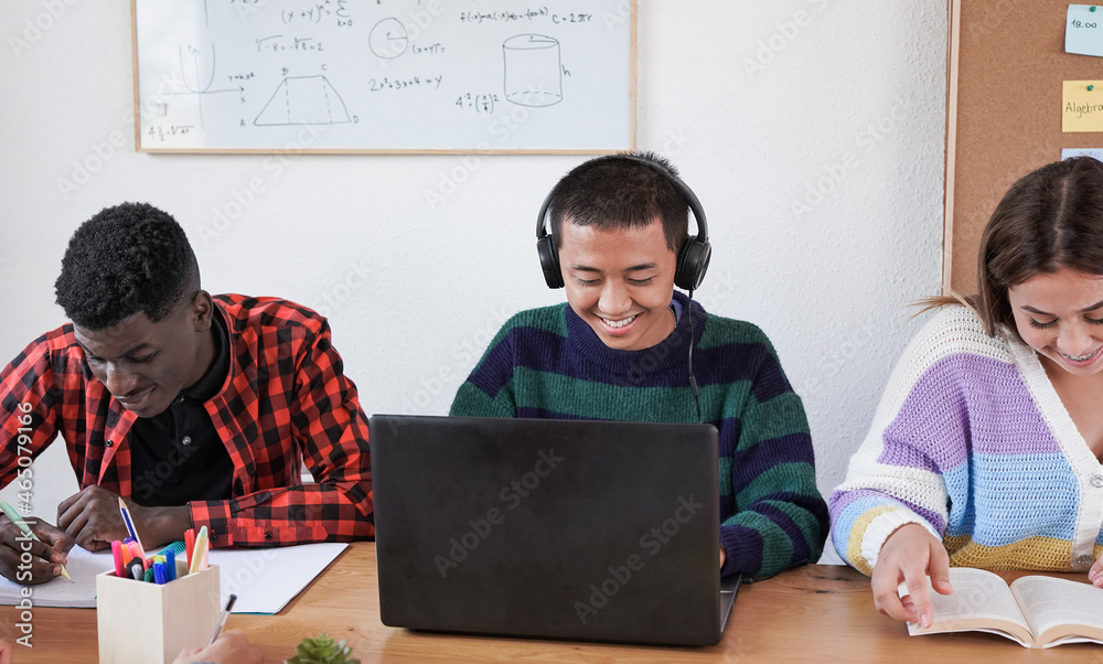 Young multiracial students learing together inside classroom using ...