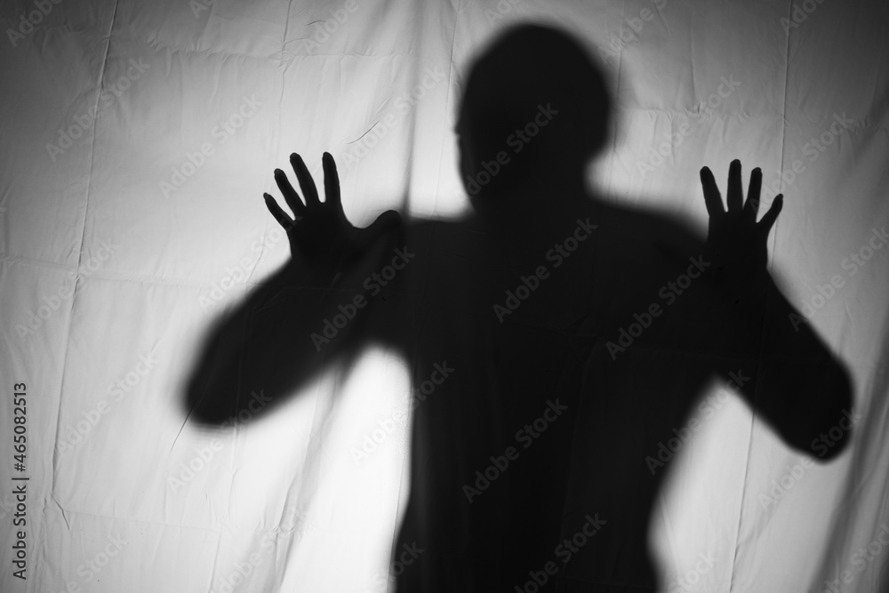 Halloween or horror concept. A terrifying shadow was behind the curtain ...