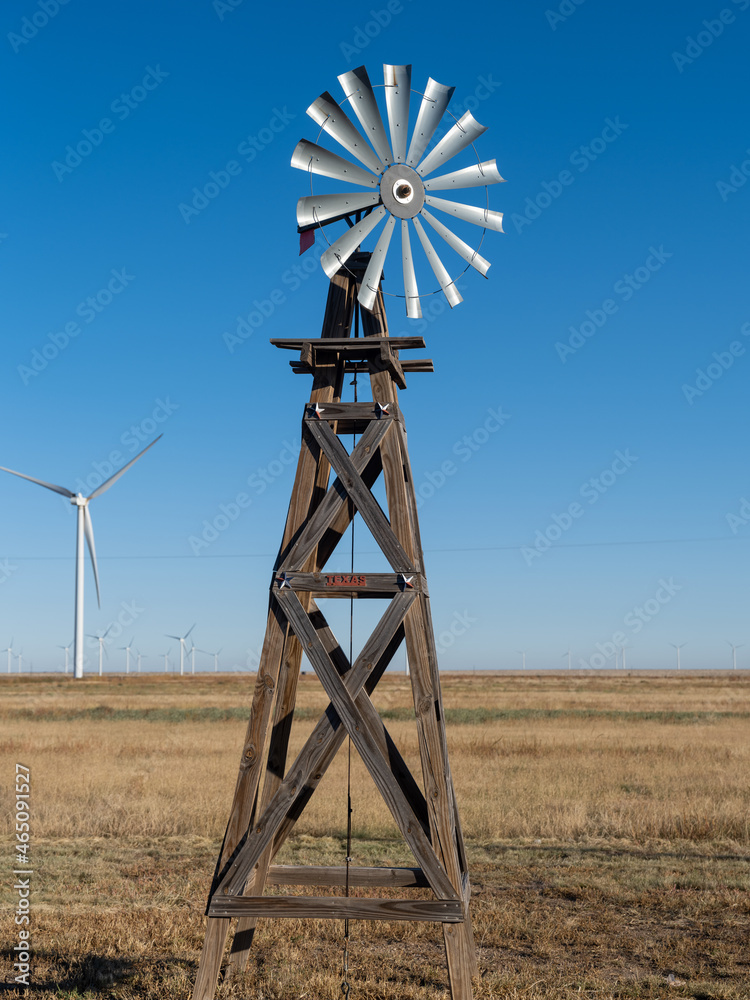 Windmills then and now. An old vintage windmill in front of a modern ...