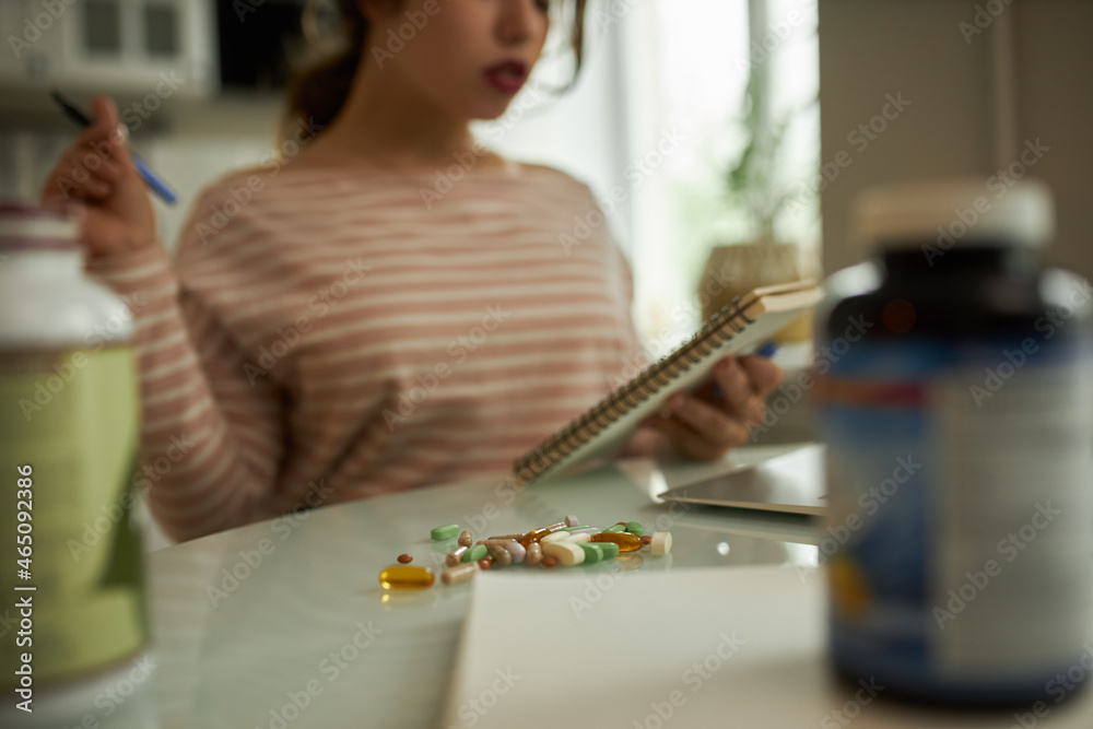 Selective focus of lots of vitamin pills and bottles standing on table ...